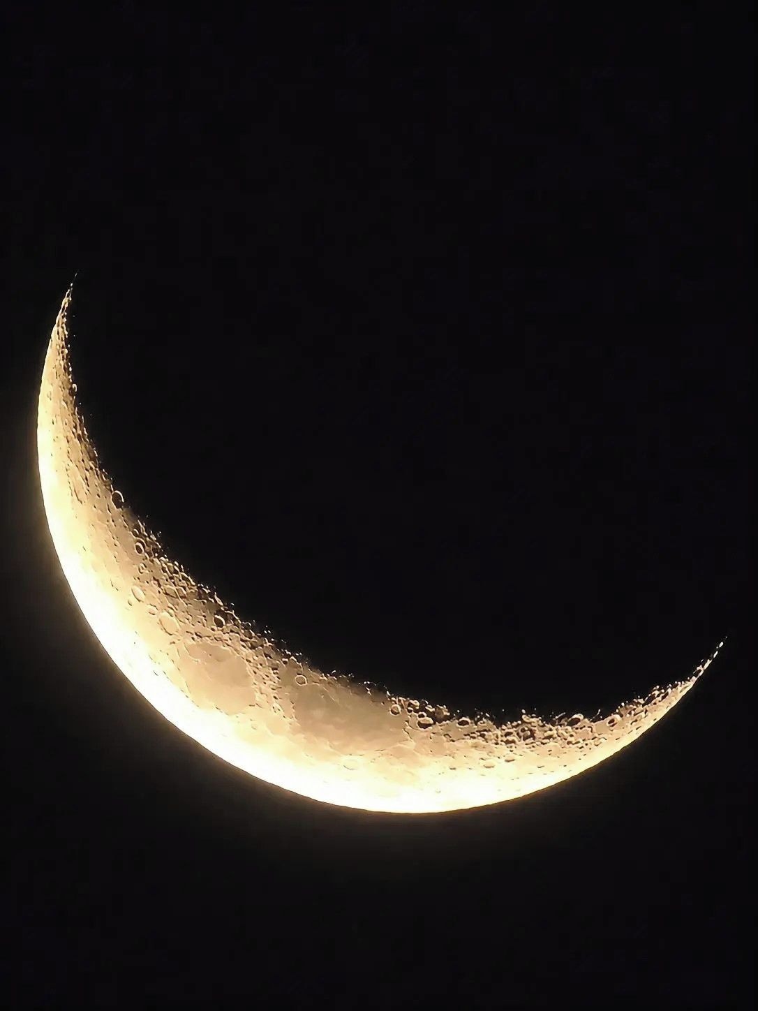 Uma lua crescente no céu noturno.
