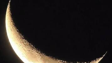 Uma lua crescente no céu noturno.