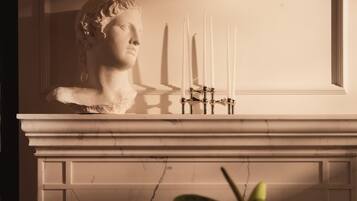 Uma lareira de mármore com busto e velas.