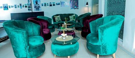 Sala de estar com sofá verde, mesa de centro e televisão de tela plana.