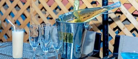 Mesa posta com uma garrafa de champanhe, copos e um refresco de leite.