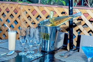 Mesa posta com uma garrafa de champanhe, copos e um refresco de leite.
