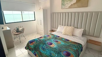 Quarto com cama, cadeira, guarda-roupa e um quadro na parede.