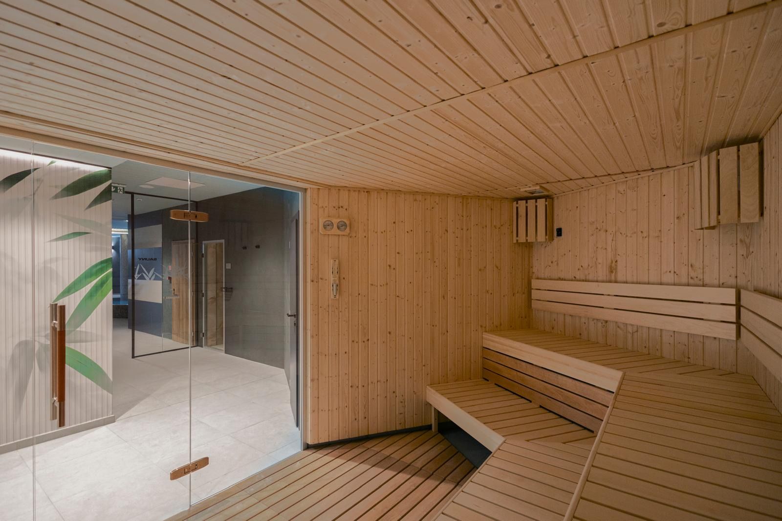 Um interior moderno com painéis de madeira, porta de entrada em vidro e um banco de madeira.