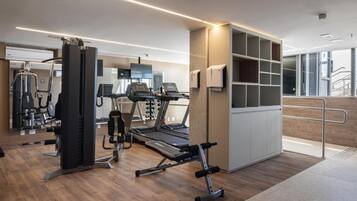 Uma academia moderna com diversos equipamentos de exercícios, incluindo esteira e aparelhos de musculação.