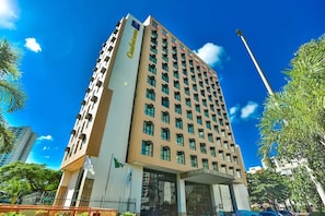 Um hotel imponente com fachada moderna, várias varandas e uma entrada destacada.