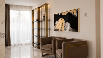 Uma sala de estar moderna com um sofá, uma estante alta e um quadro na parede.