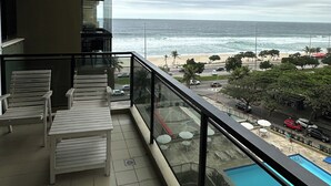 Varanda com vista para o oceano, piscina e área de estar externa.
