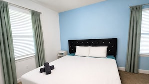 Quarto de hotel com uma cama grande, uma mesa de cabeceira e uma cabeceira.