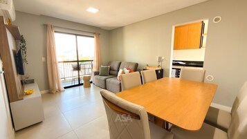 Um apartamento moderno com área de jantar, cozinha e varanda com vista.