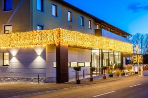 Um hotel com fachada moderna, grandes janelas e entrada bem iluminada.