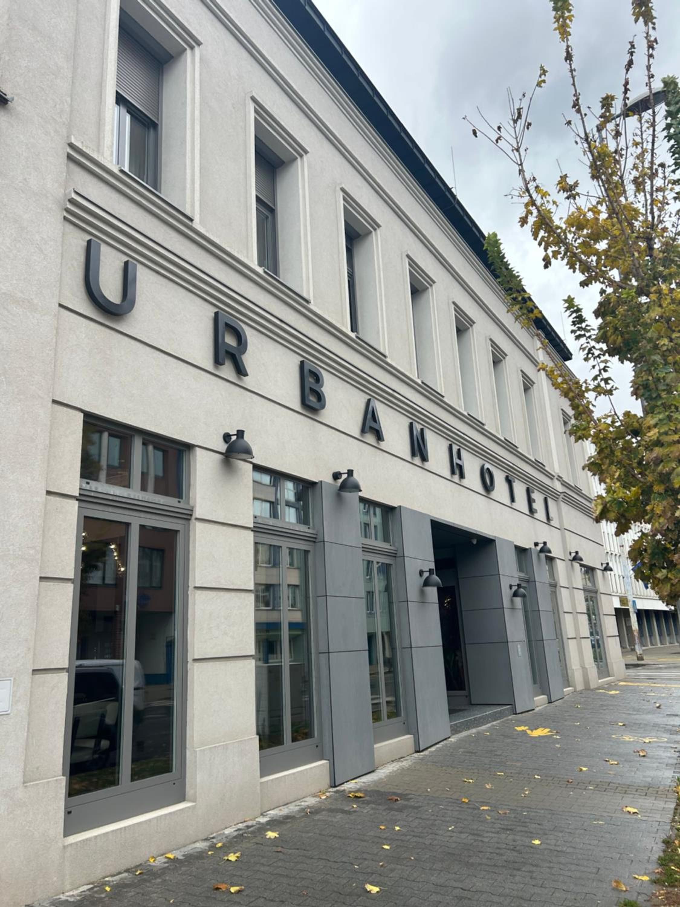 Edifício com a placa 'URBANGOTEL', indicando um estabelecimento hoteleiro.