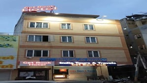 Um hotel com uma placa indicando 'Get Book Hotel', uma placa 'India Tours & Travels' e uma placa 'Get Book Cab'.