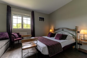 Quarto com cama, cadeira, mesa e janela.