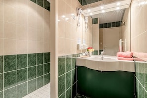 Casa de banho com lavatório, espelho e porta-toalhas.