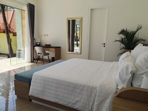 Quarto com cama, escrivaninha, cadeira, espelho e planta em vaso.