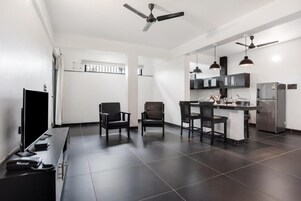 Cozinha moderna com azulejos escuros, ilha central e iluminação pendente.
