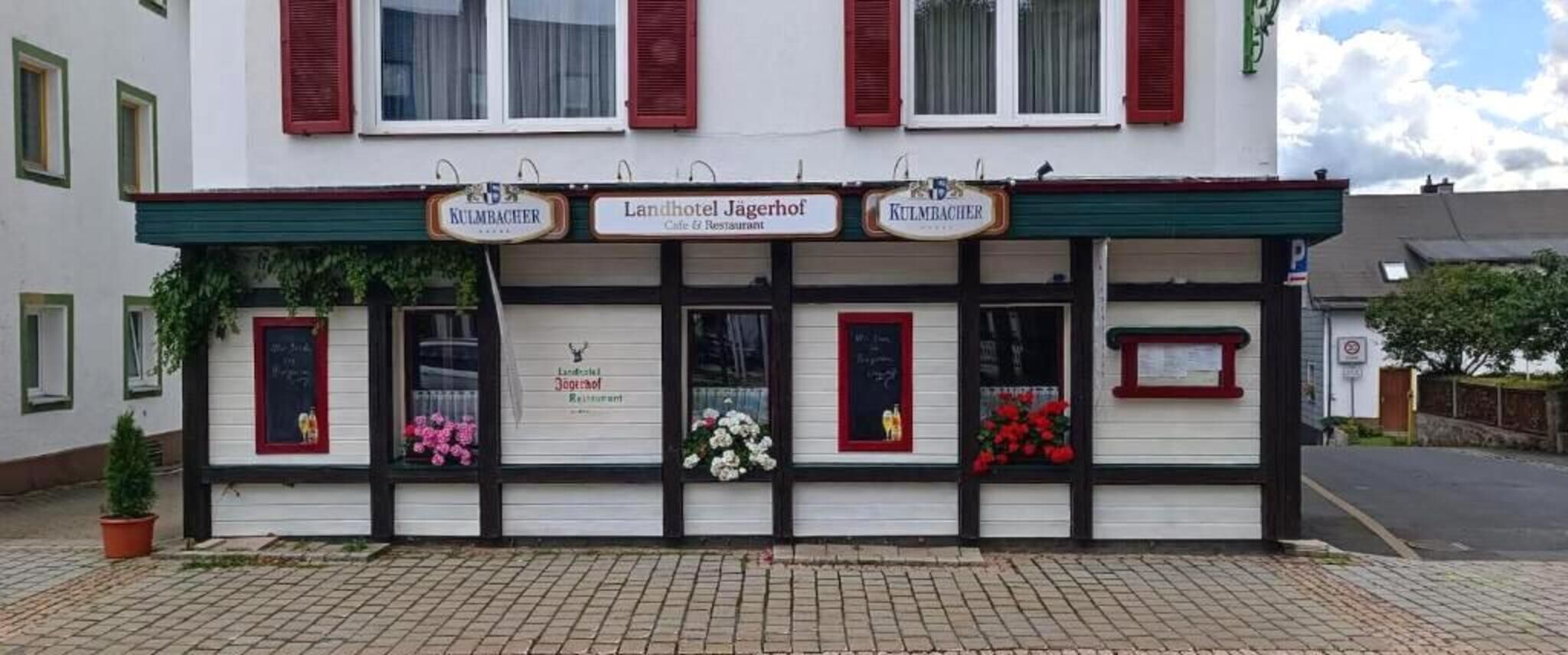 Um edifício com placa indicando 'Landhotel Jägerhof' e café & restaurante 'Kulmbacher'.