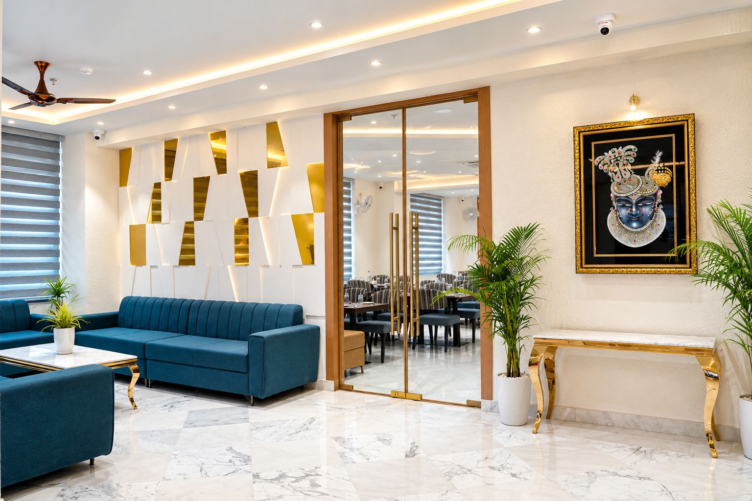 Um saguão de hotel moderno com um sofá azul, piso de mármore e um painel decorativo na parede.
