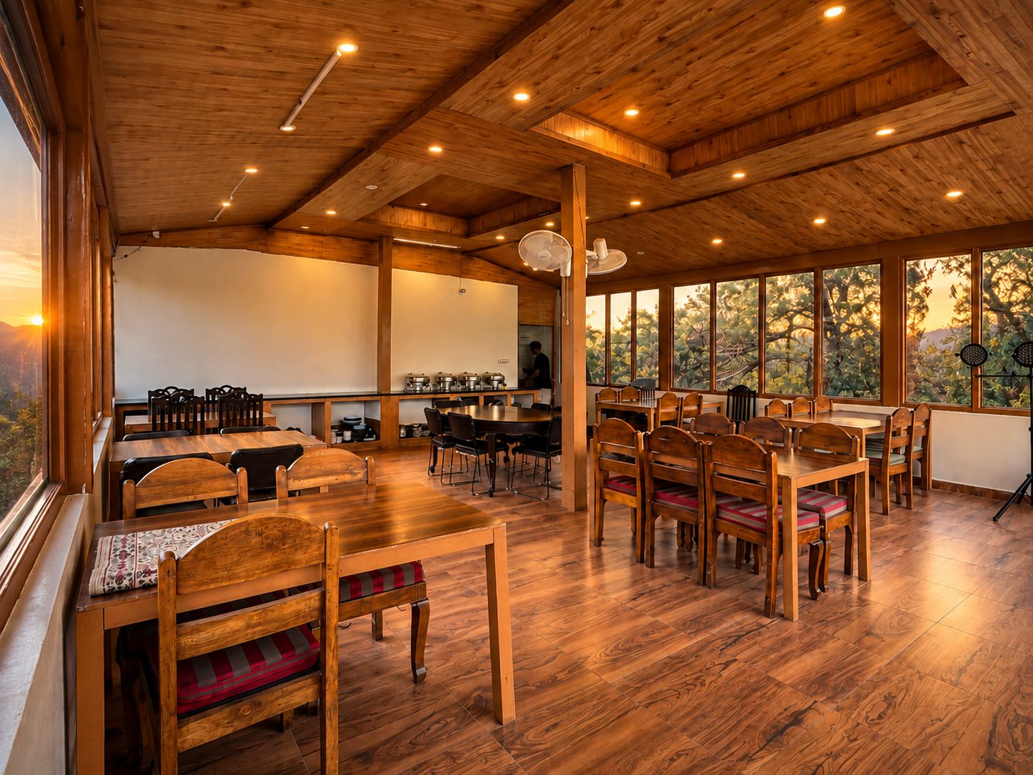 Ampla sala de jantar com mobiliário de madeira e grandes janelas com vista para o exterior.