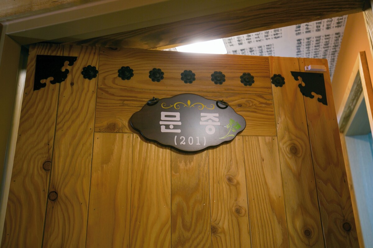 Uma porta de madeira com uma placa decorativa e uma maçaneta de metal.