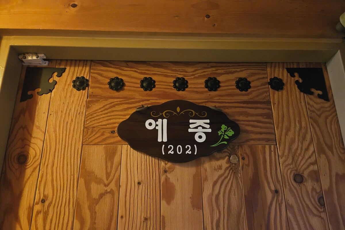 Parede de madeira com uma placa que diz '이 정' e o ano '2021'.