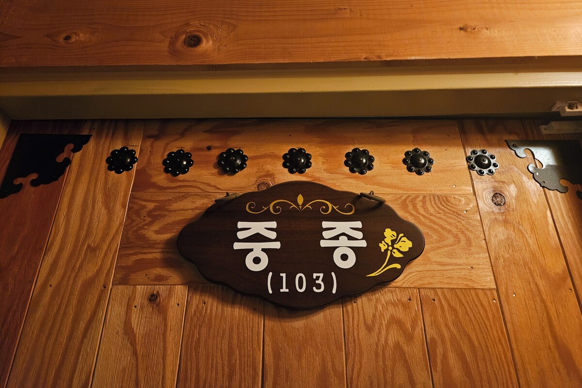 Piso de madeira com uma placa decorativa e objetos em formato de flor pretos.