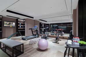 Um centro de fitness moderno com esteiras, aparelhos elípticos e bolas de exercício.