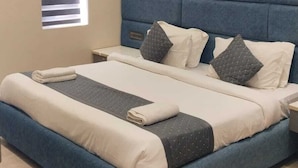 Quarto moderno com cama grande, ventoinha no teto e janela com persianas.
