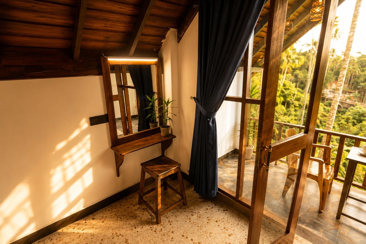Quarto com um banco de madeira, um banquinho, um espelho e vista para uma varanda com cadeiras e uma mesa.