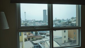 Janela com múltiplos painéis exibindo vista de um horizonte urbano, incluindo edifícios e uma torre.