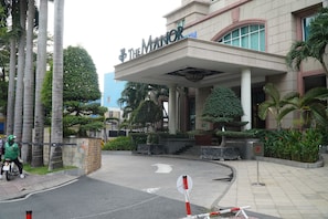 Entrada de hotel com uma placa indicando 'The Manor'.