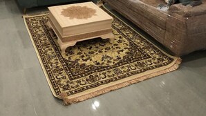 Sala de estar com dois sofás, uma mesa de centro e um tapete estampado.