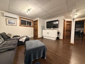 Uma sala de estar com sofá, televisão e armário.