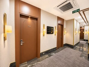 Corredor de hotel com portas numeradas 211, 210 e 216 a 220, e placas de sinalização.