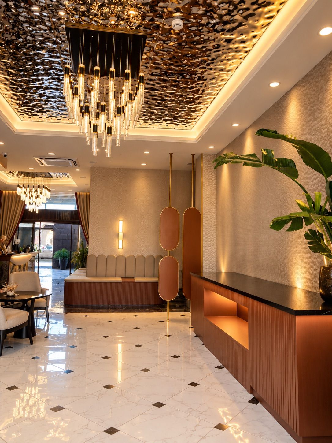 Um saguão de hotel com balcão de recepção, área de estar e teto decorativo.