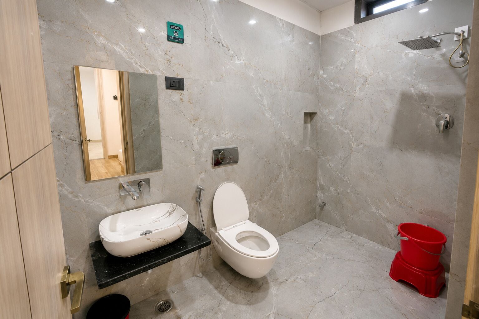 Um banheiro moderno com pia, vaso sanitário e chuveiro de mármore.