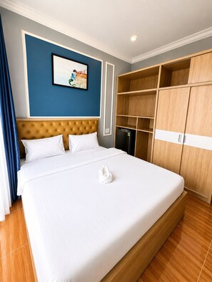 Quarto de hotel com uma cama grande, um guarda-roupa e um quadro na parede.