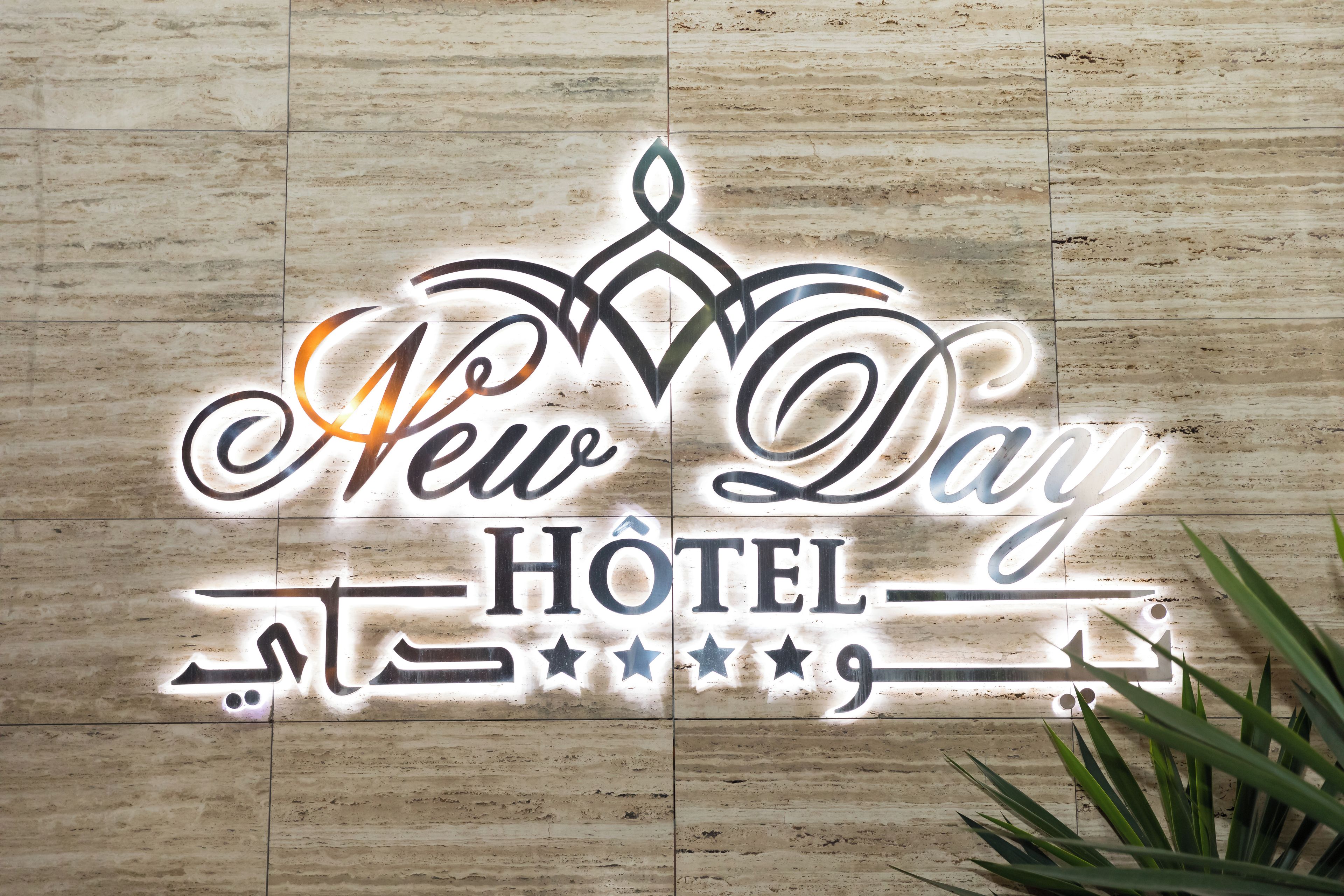 Placa de hotel com 'New Day HOTEL' e detalhes decorativos.