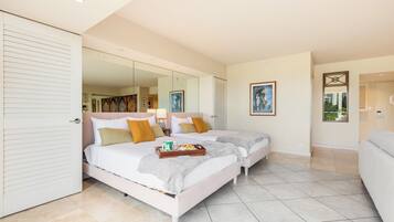 Quarto moderno com duas camas, um espelho grande e um espaço de refeições com uma bandeja de comida.