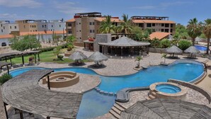 Resort com uma grande piscina, áreas de estar ao ar livre e vista dos edifícios ao redor.