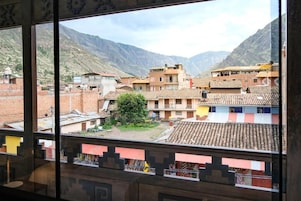 Vista de uma aldeia montanhosa com edifícios tradicionais e céu claro.