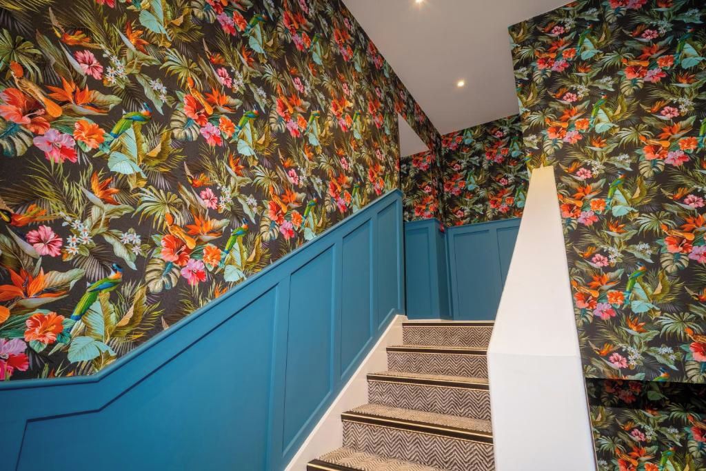 Uma escadaria com parede estampada e luminária branca.
