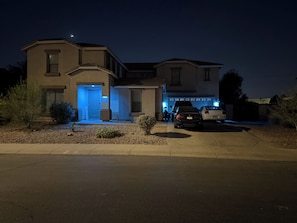 Uma casa de dois andares com garagem, entrada por automóvel e gramado bem cuidado.