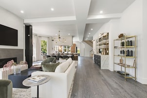 Uma sala de estar moderna com lareira, um sofá, uma mesa de centro e uma estante de livros.