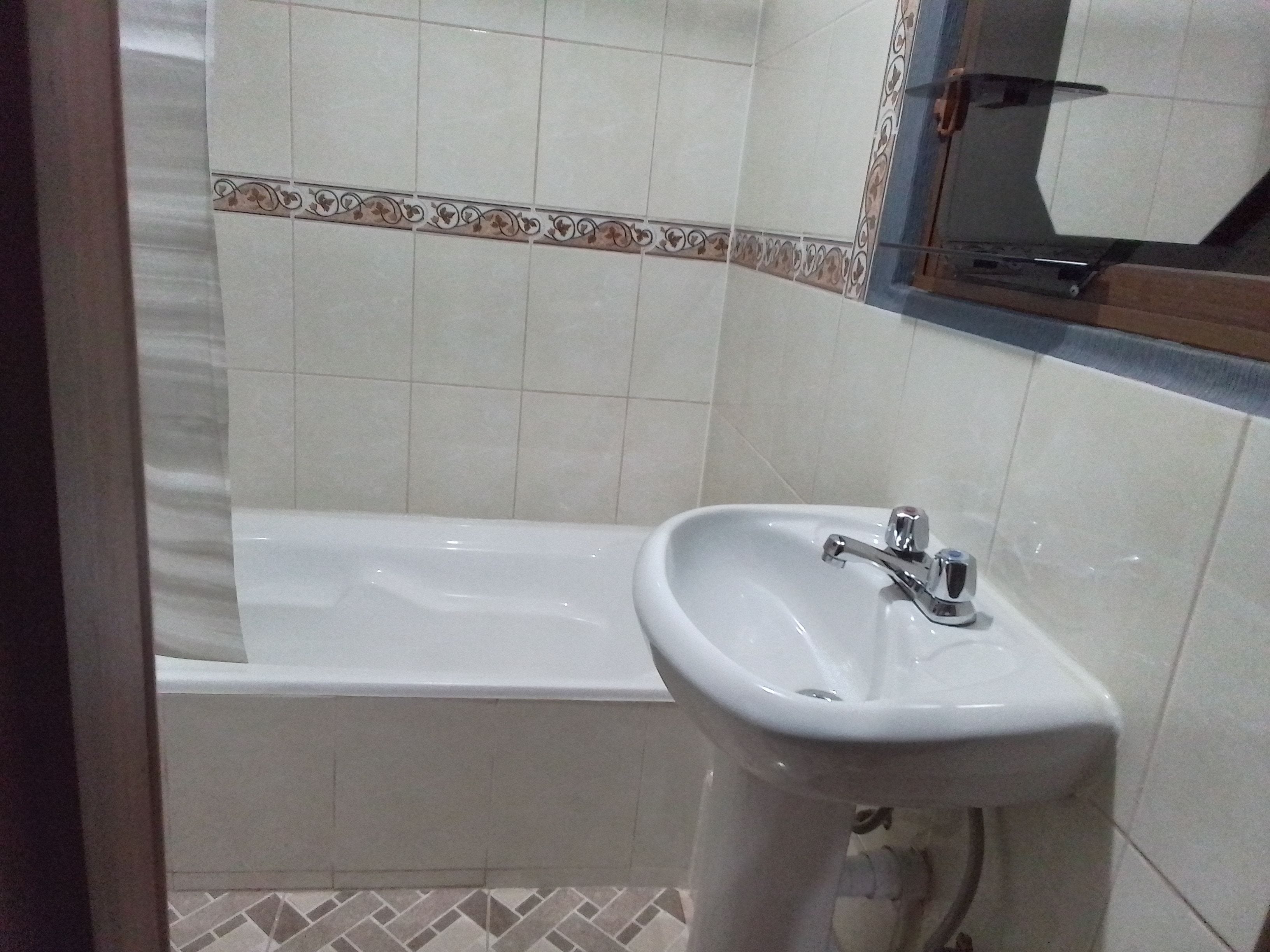 Casa de banho com banheira, pia e espelho.