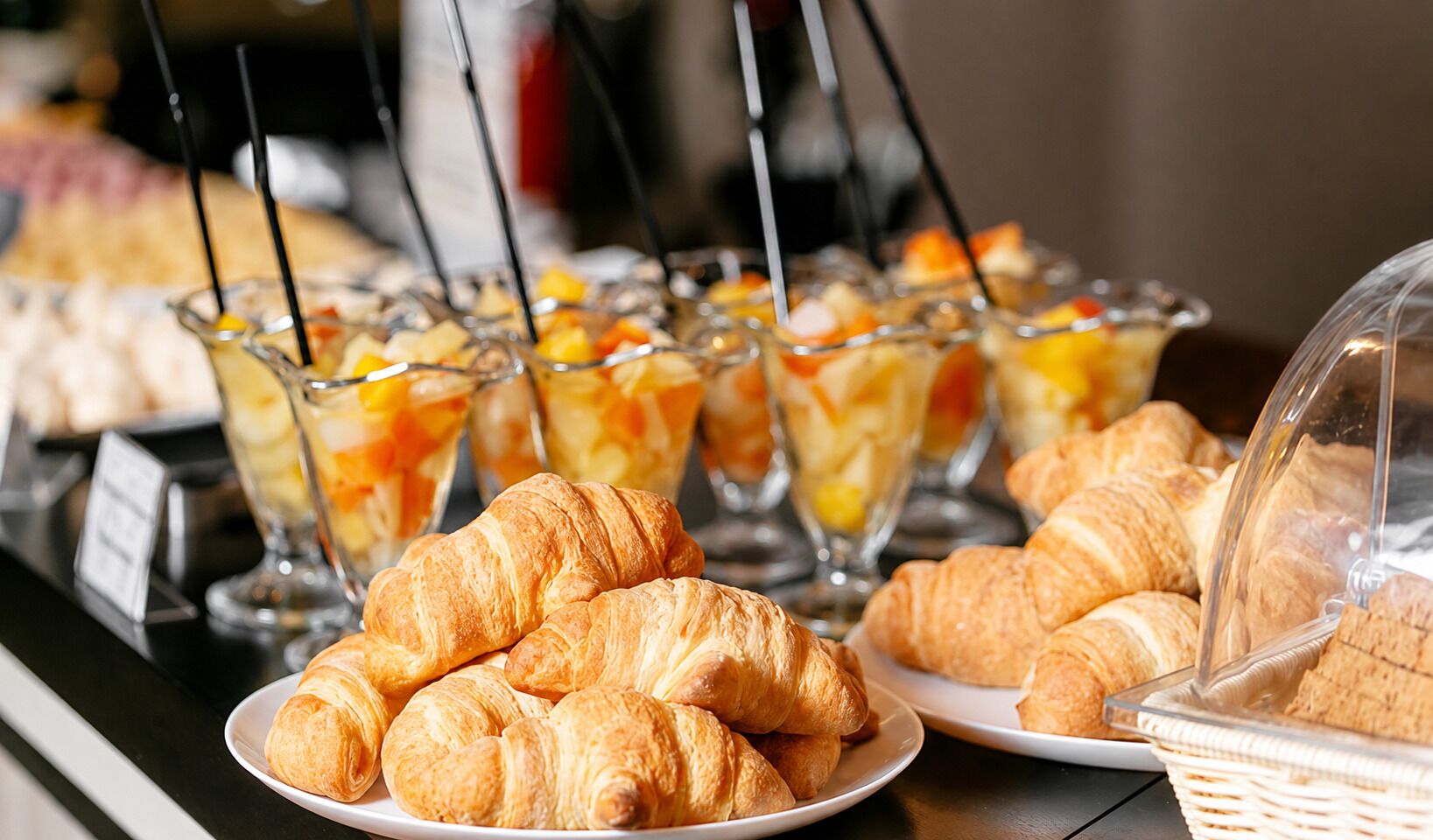 Buffet com croissants e pêssegos em camadas.