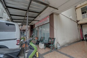 Edifício com placa, uma scooter estacionada e um banco na frente.