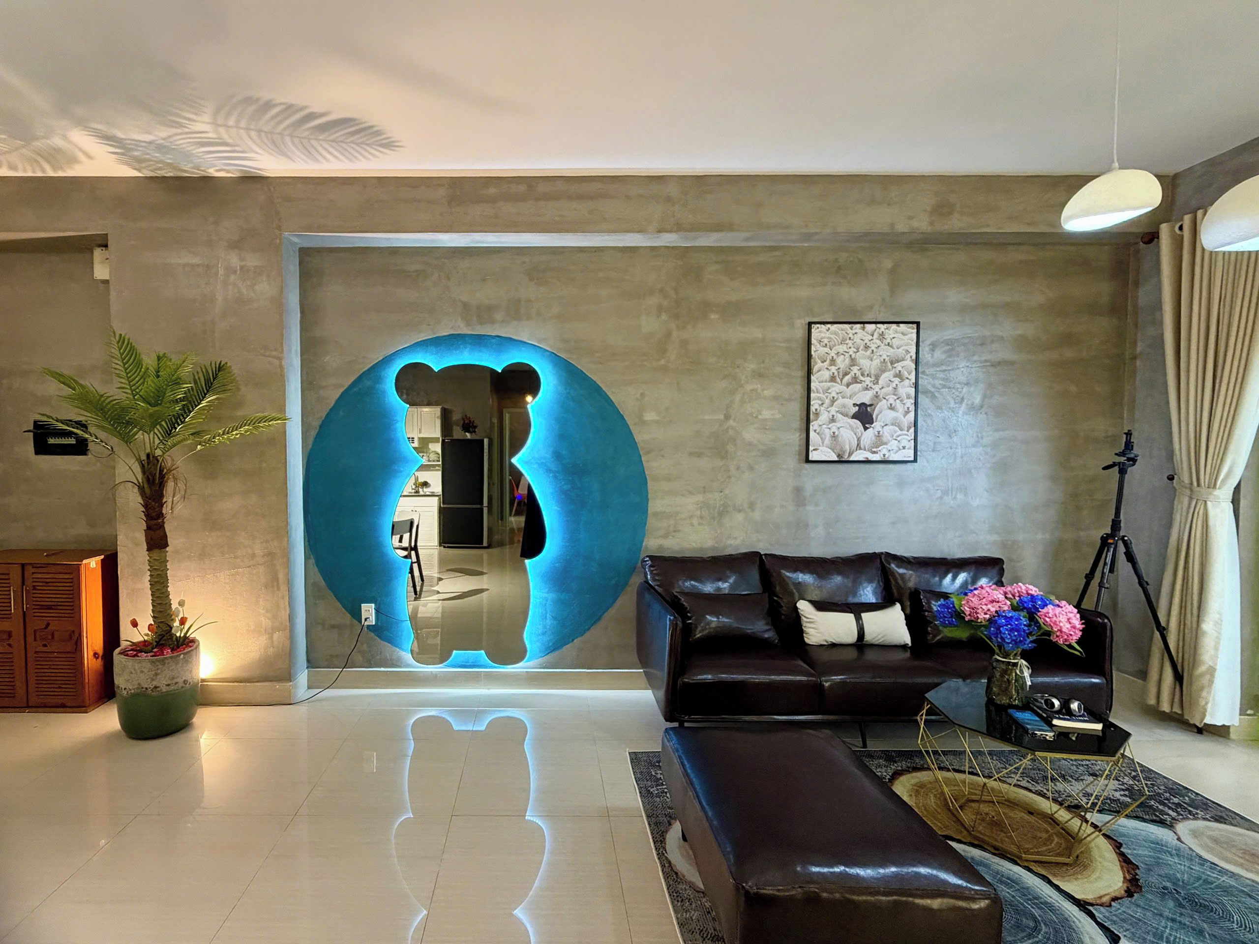 Uma sala de estar moderna com sofá, mesa de centro e espelho em formato de urso.