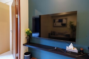 Uma casa de banho moderna com um espelho grande, uma pia pequena e um cesto de lixo.